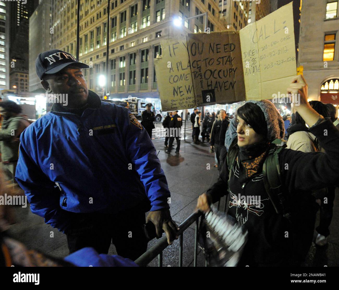 A New York City Police officer reads a protester's sign at the eastern ...