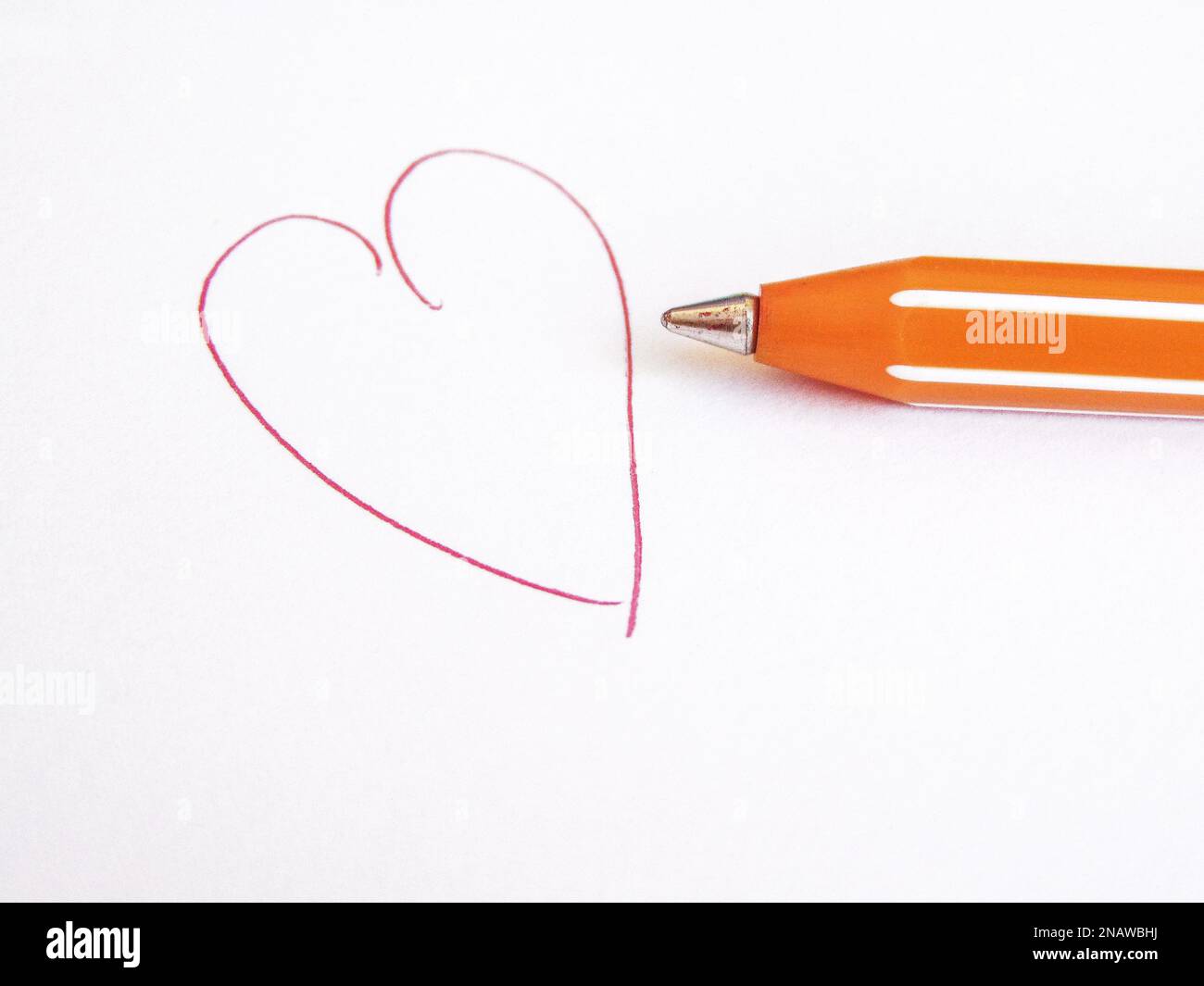 The shape of a heart made on paper with a pen writing in red color ...