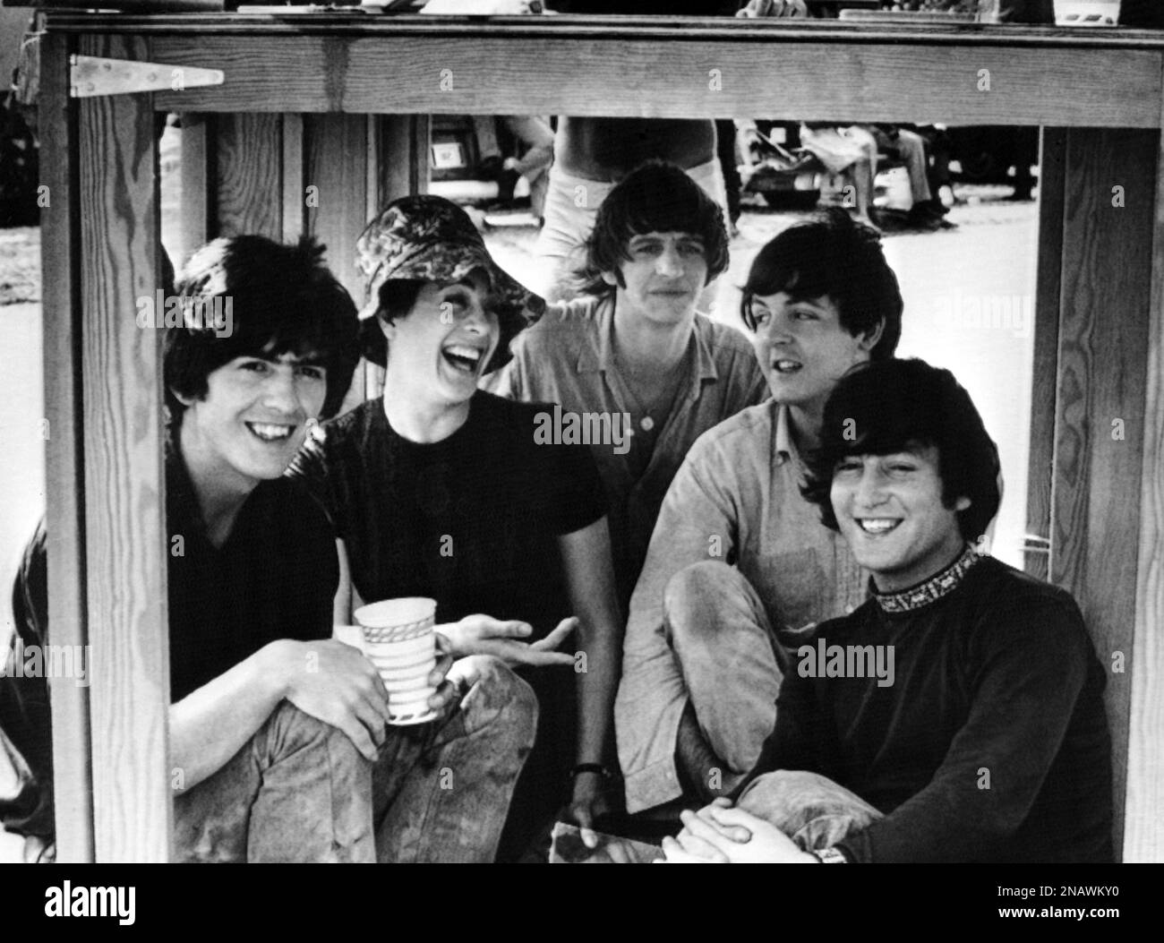 The four Beatles with their leading lady take cover from the sun while ...