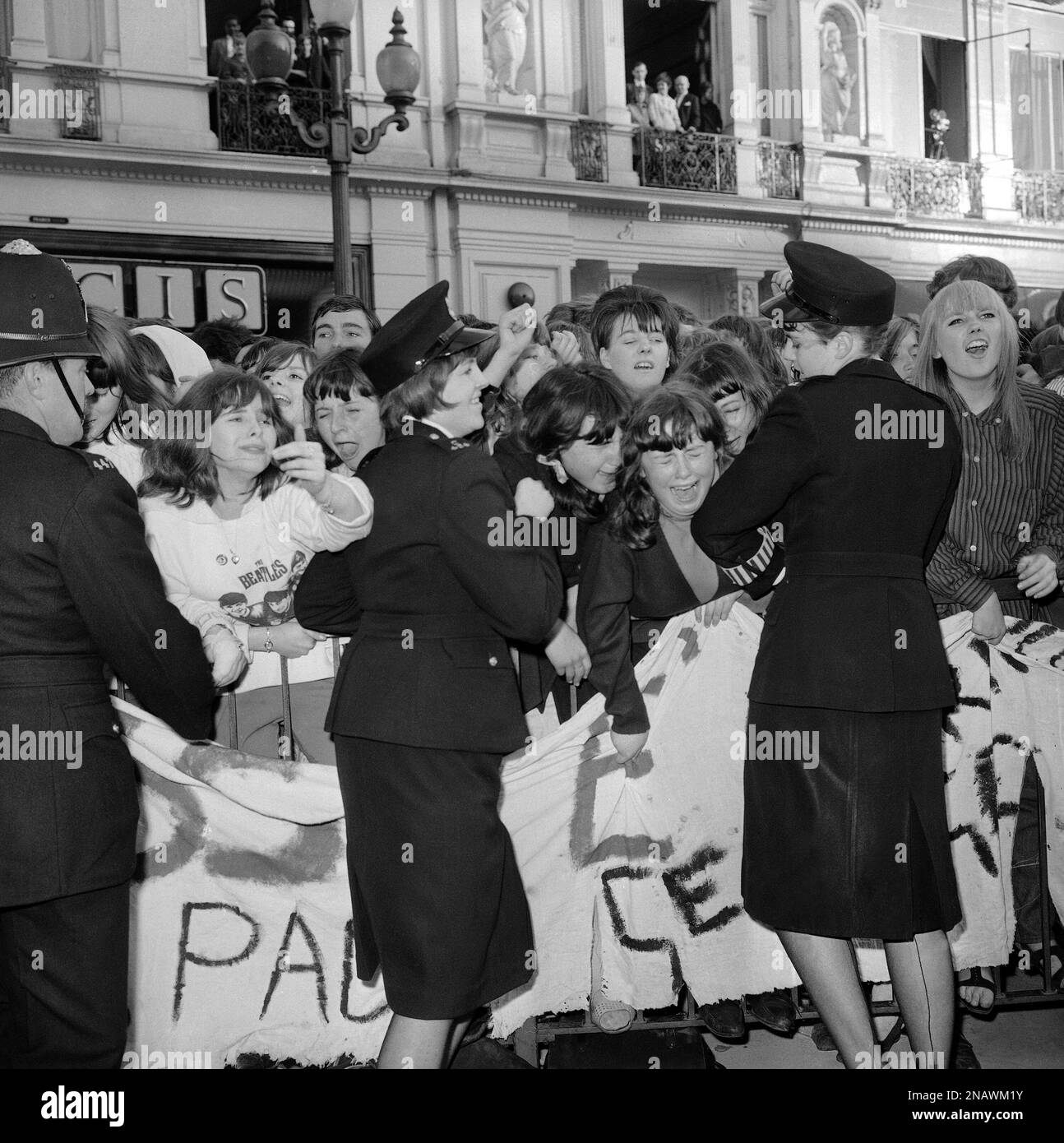 Female police officers stand in front of screaming fans as a crowd of ...