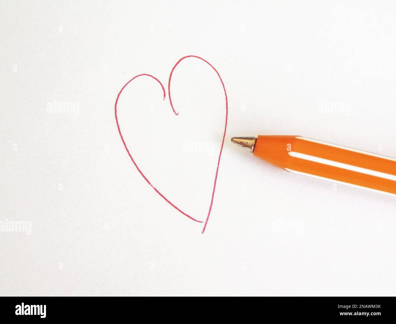 The shape of a heart made on paper with a pen writing in red color ...