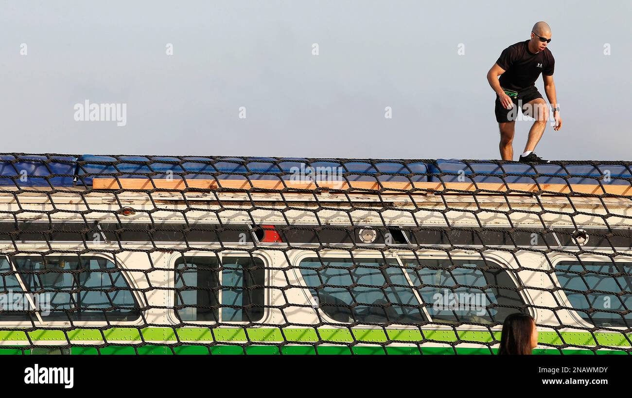 Urbanathlete scale a bus obstacle during the Men's Health Urbanathlon ...