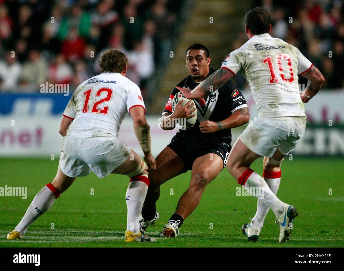 New Zealand's Sika Manu, center, runs at England's Jamie Peacock, right ...