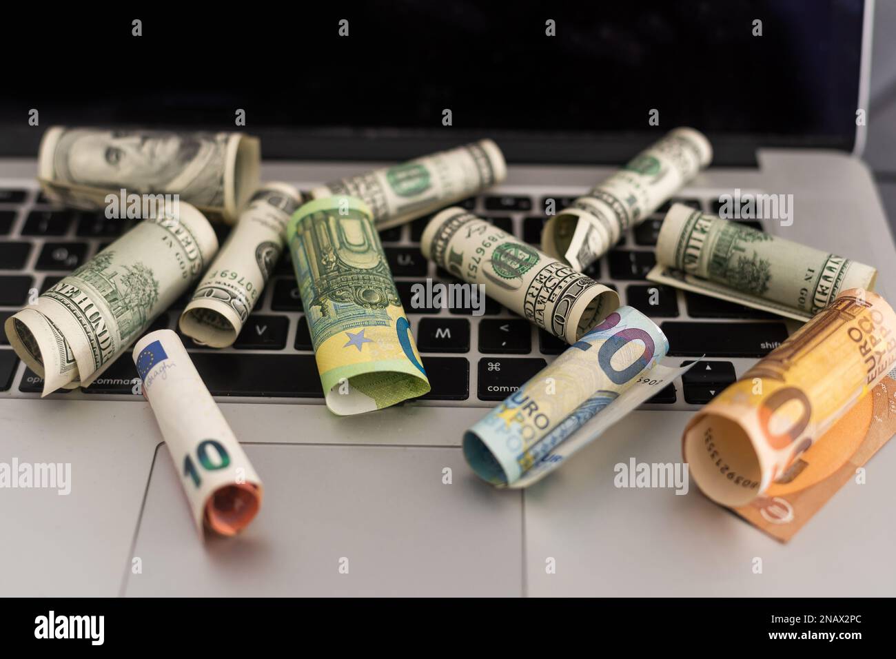 Money on computer keyboard. roll Stock Photo - Alamy