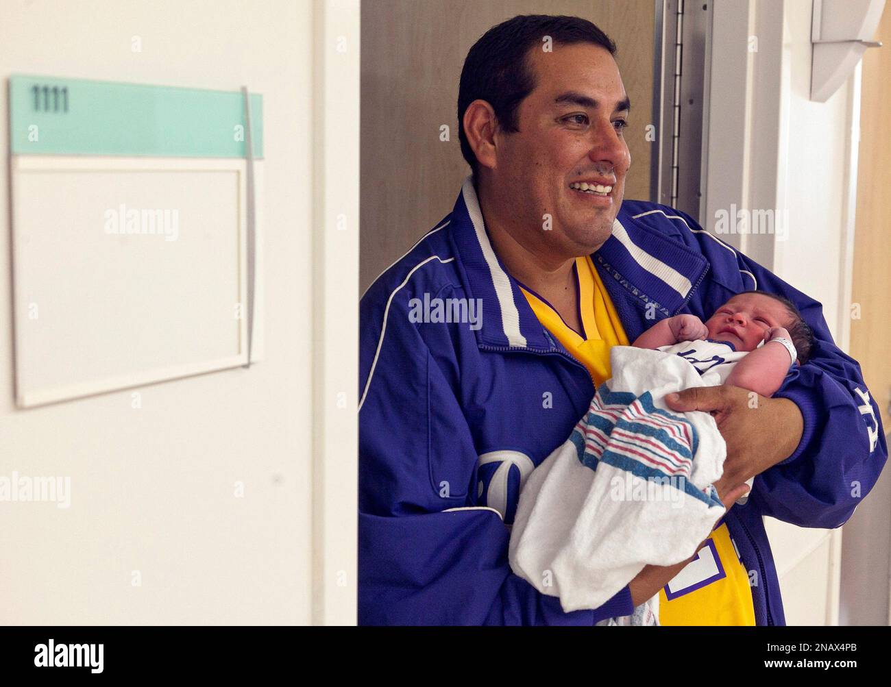 Pete Ruiz holds his newborn son, Alexander, who was delivered at 11:11 ...