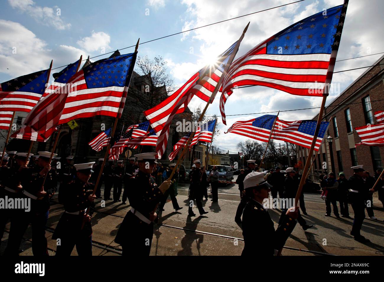 U.S. Marine Corps ROTC carry flags during a Veteran's Day parade Friday ...