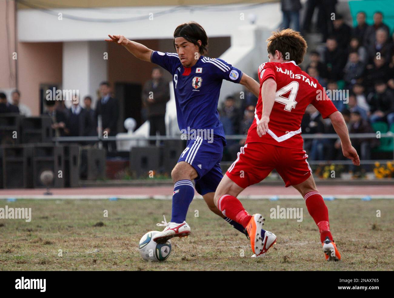 Japan's Shinji Okazaki, left, challenges for the ball with Tajikistan ...