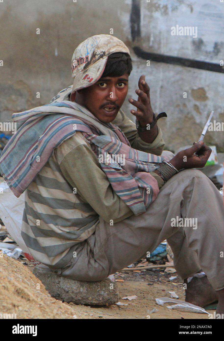 A Pakistani drug addict reacts to be photographed at a roadside in ...