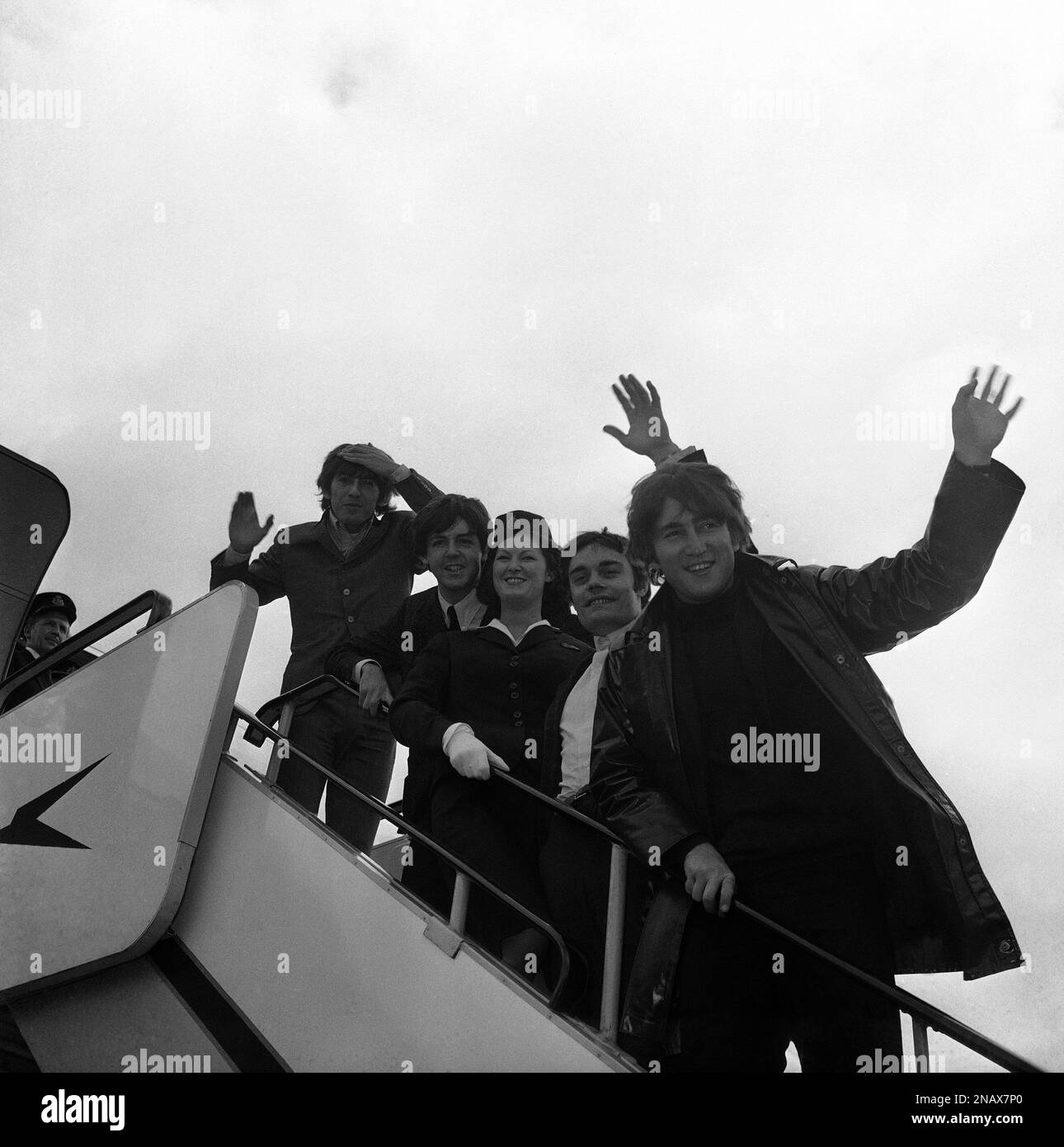 Windswept and waving, the Beatles arrive at London Airport in England ...