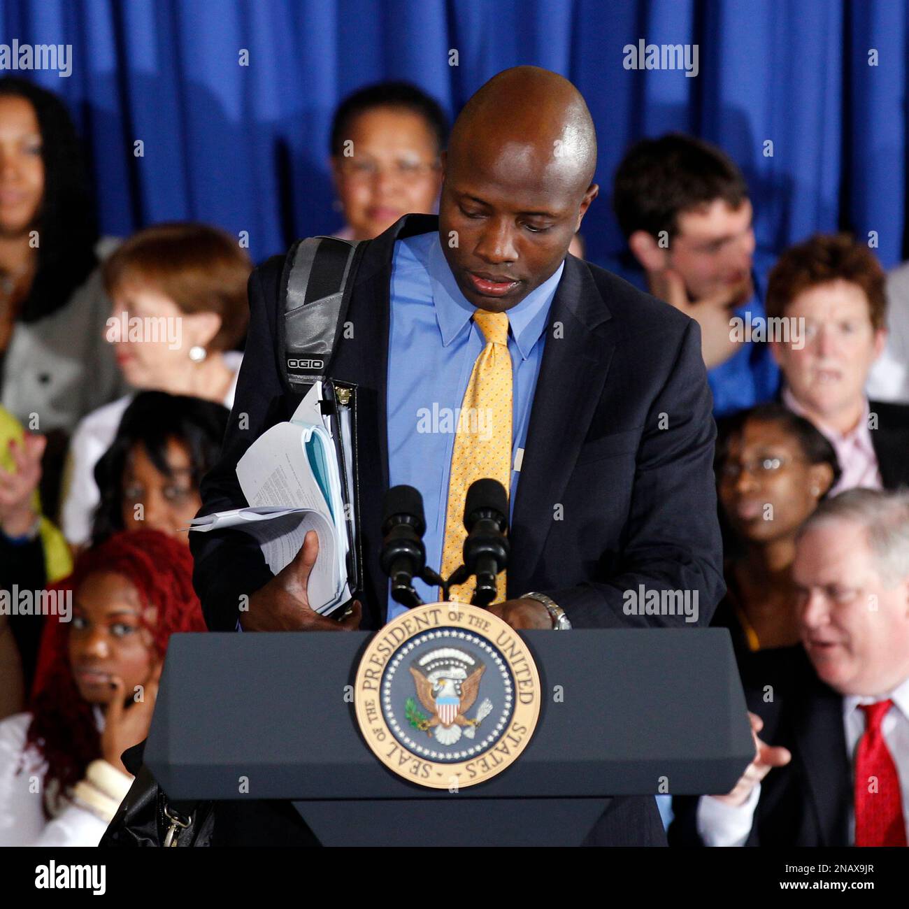 Assistant Reggie Love places a speech at the podium before President ...
