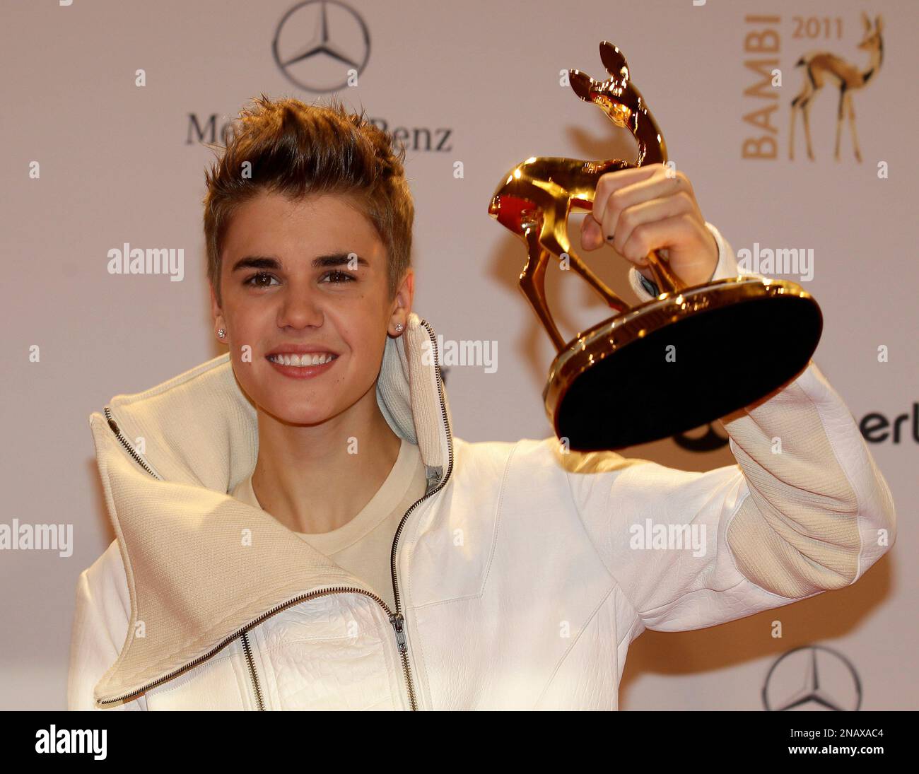 Canadian singer Justin Bieber poses with the trophy after receiving the ...