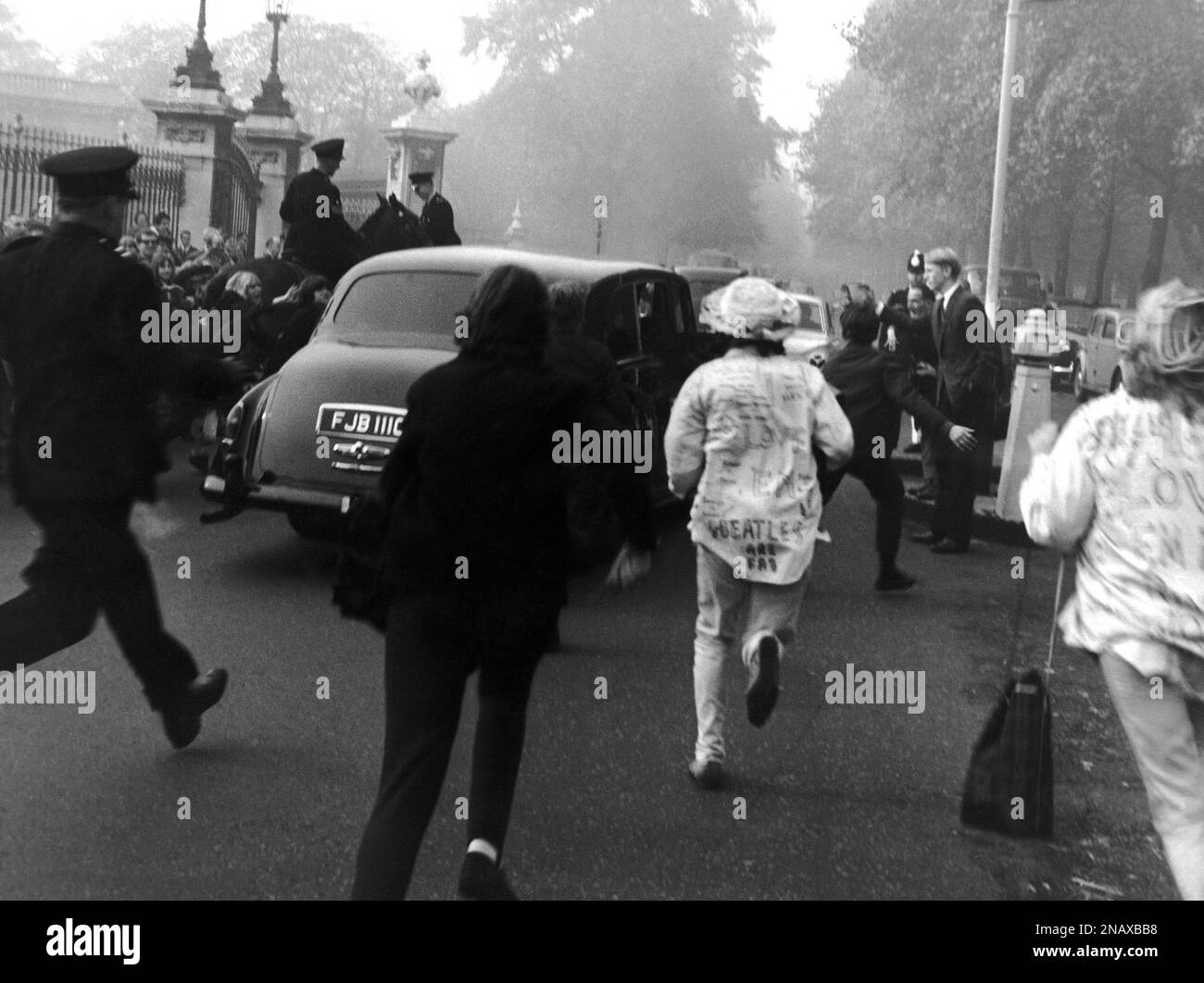 Police run after the fans chasing the car carrying the Beatles from ...
