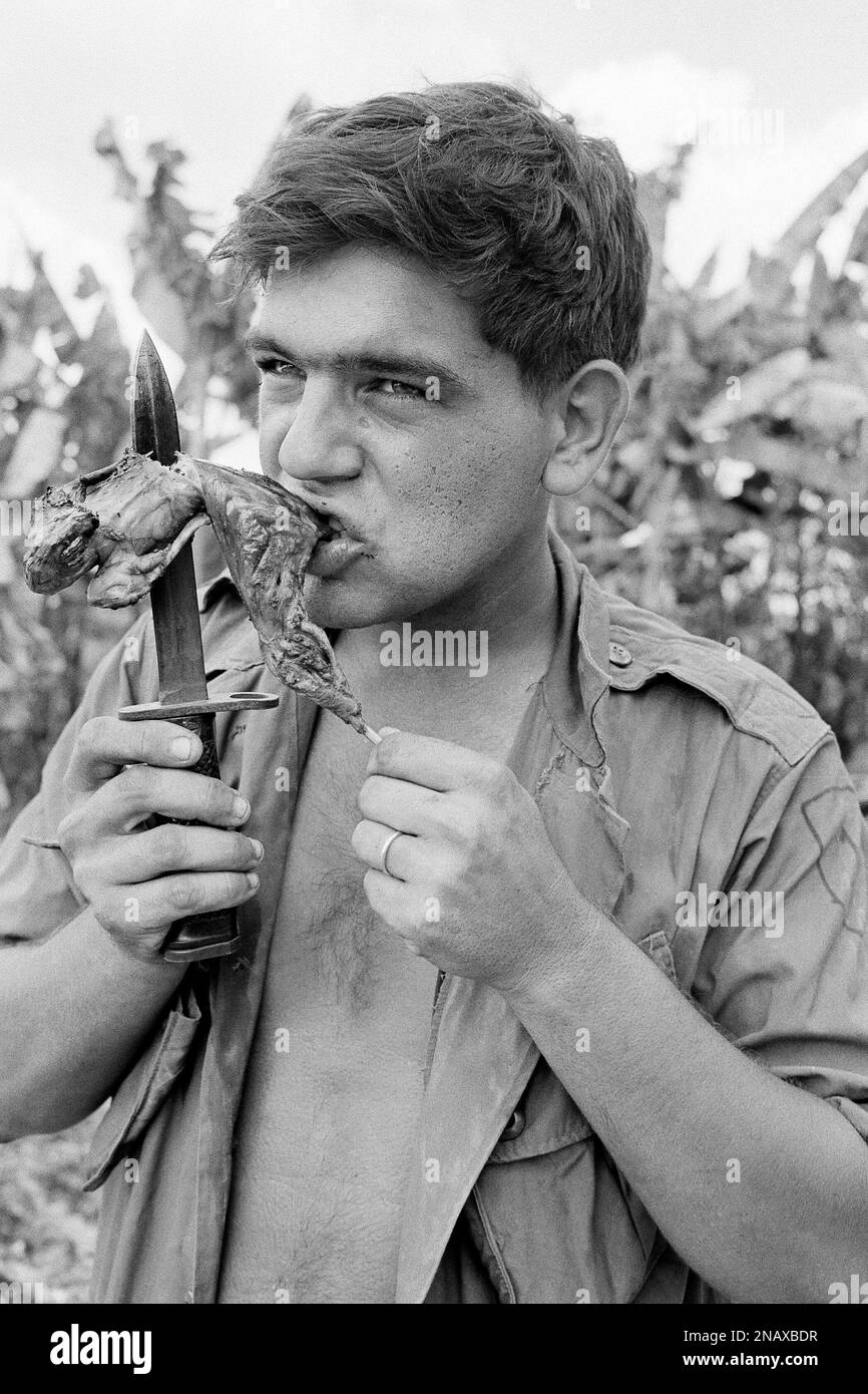 Specialist Jerry Ritchie of Marietta, Ohio, chomps on a chicken spiked ...