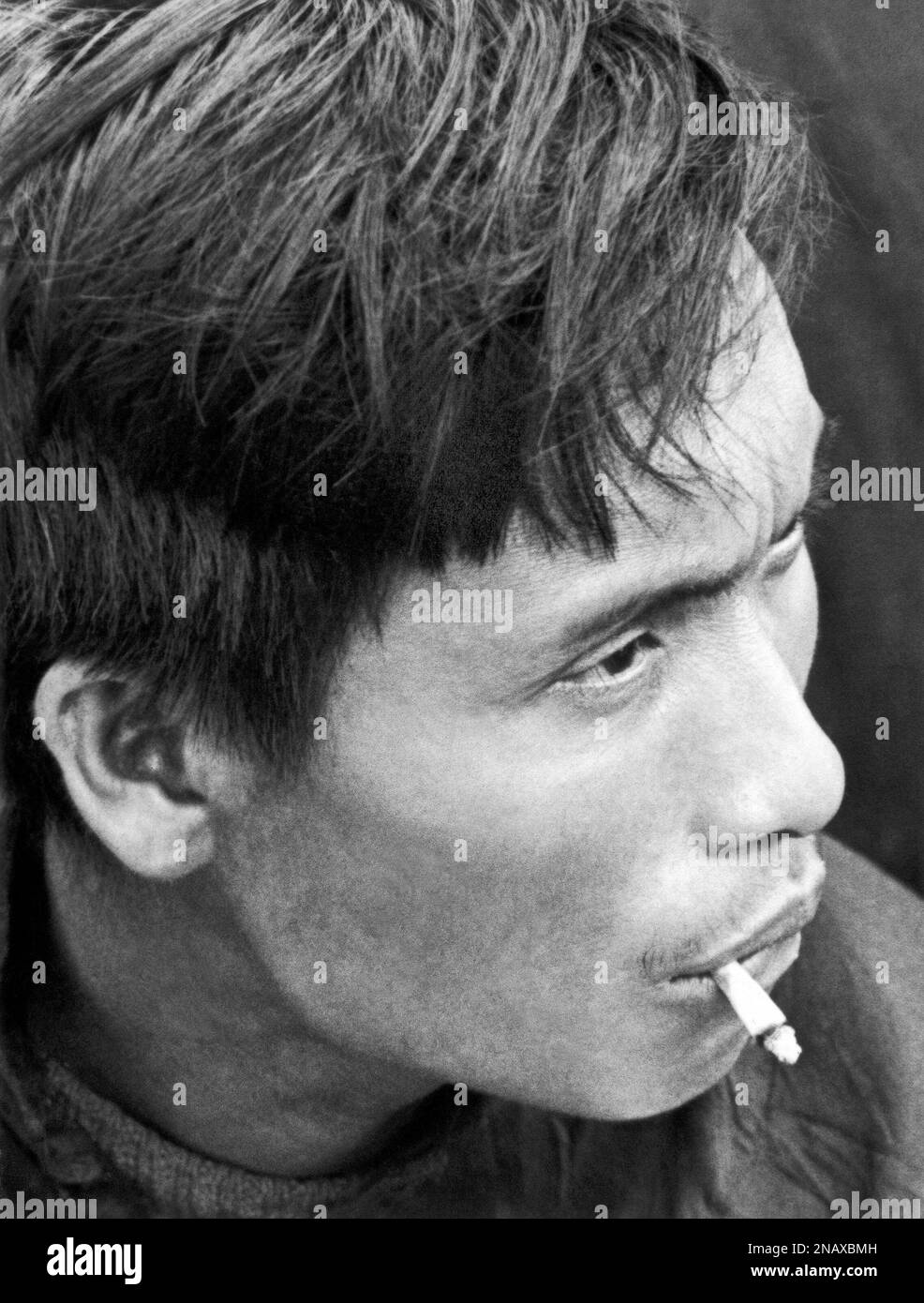 Cigarette dangles from lips of captured Viet Cong guerrilla in Vietnam ...