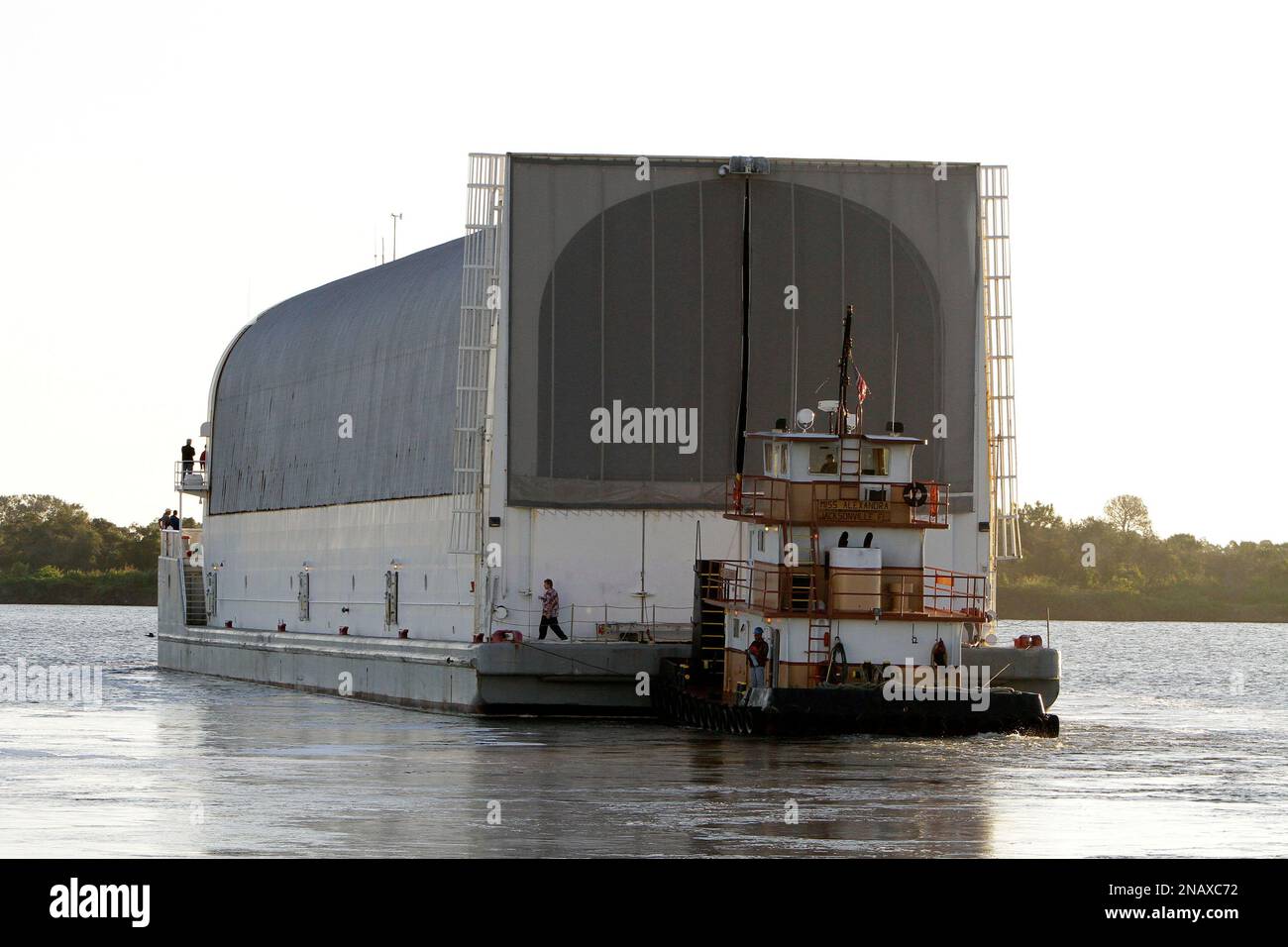 The Pegasus barge, center, guided by tugboats, leaves the Kennedy Space ...