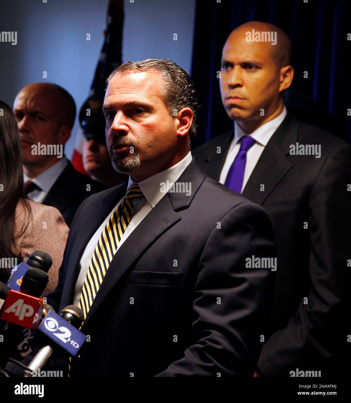 Newark Mayor Cory Booker, right, listens in Paterson, N.J., Wednesday ...