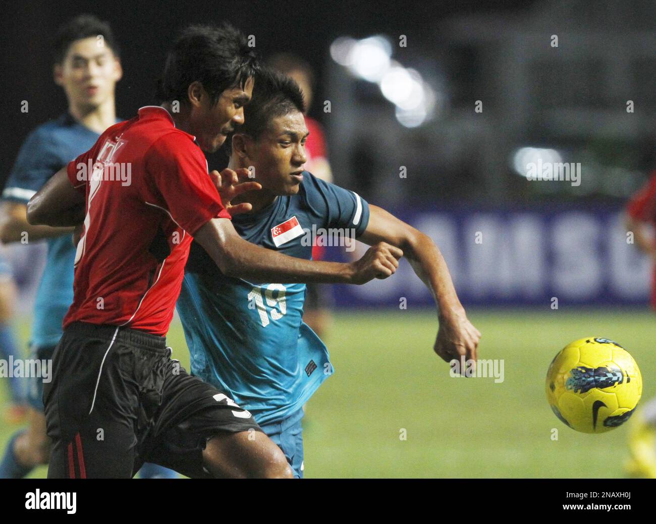 Singapore' Muhammad Firdaus Bin Kasman, right, battles for the ball ...