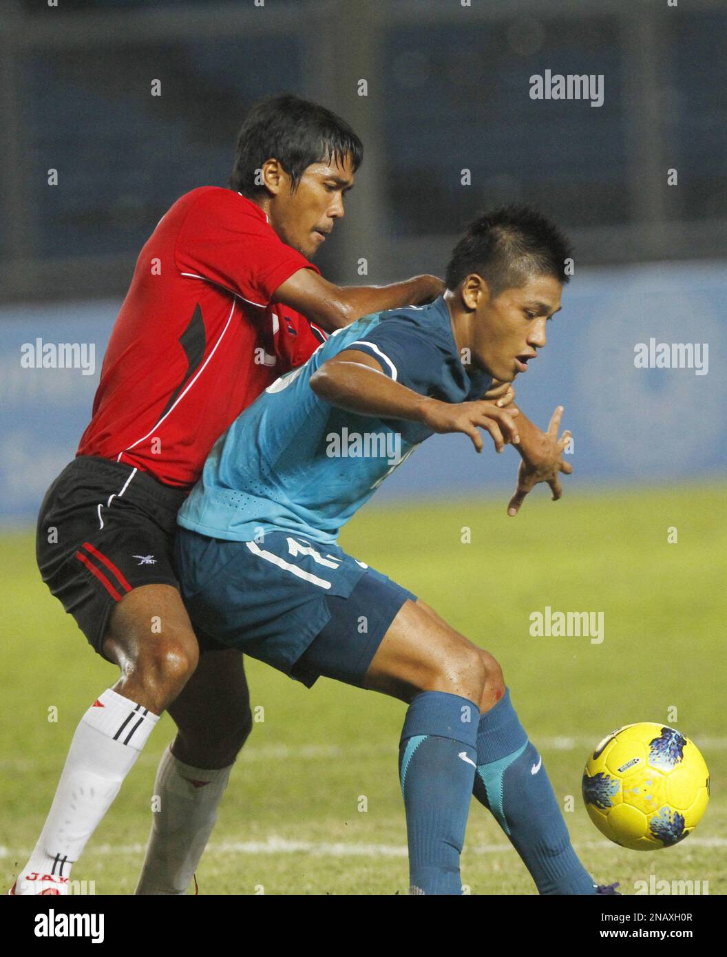 Singapore's Muhammad Khairul Nizam, right, battles for the ball with ...