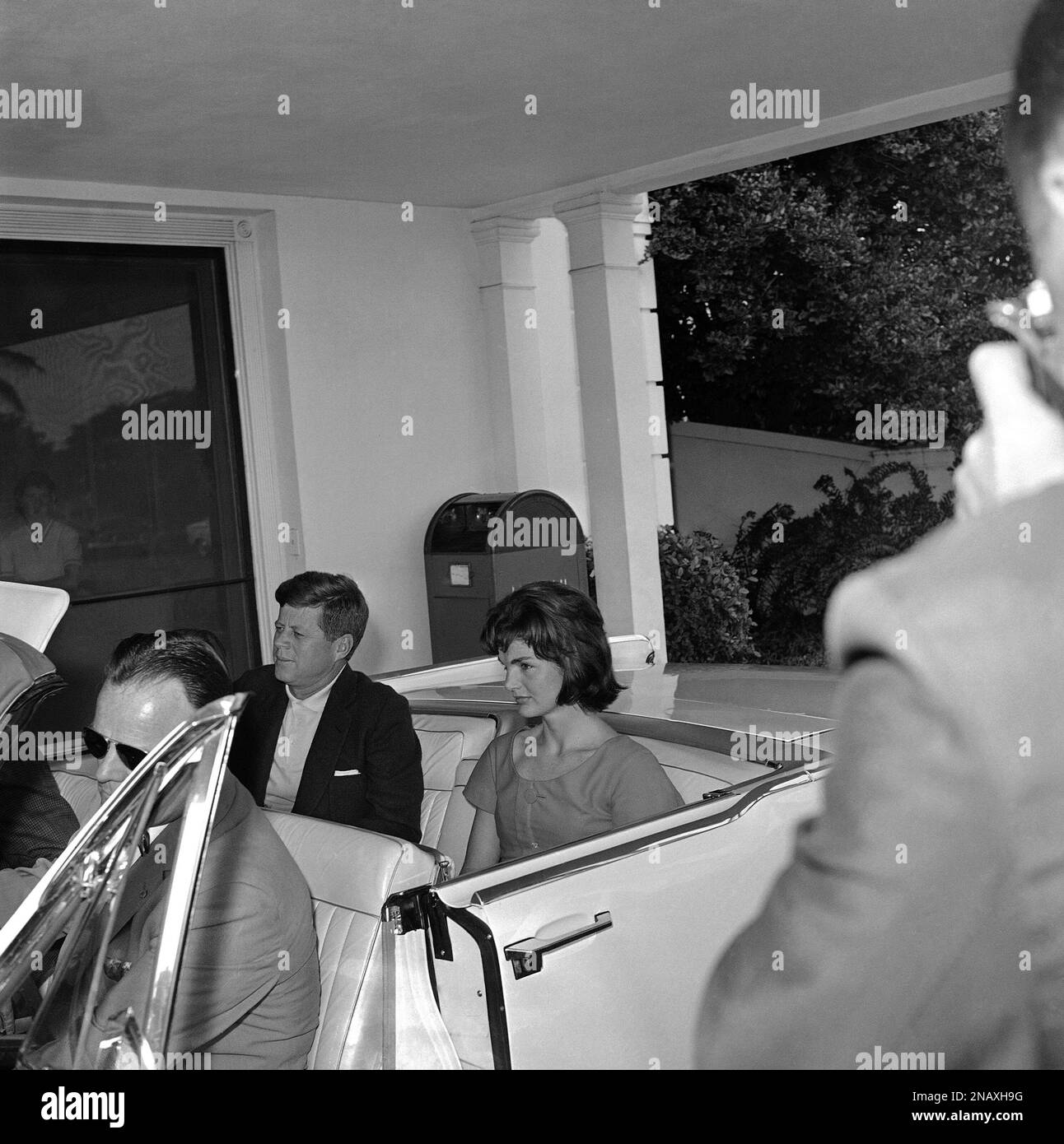 President John F. Kennedy and first lady Jacqueline Kennedy sit in rear ...