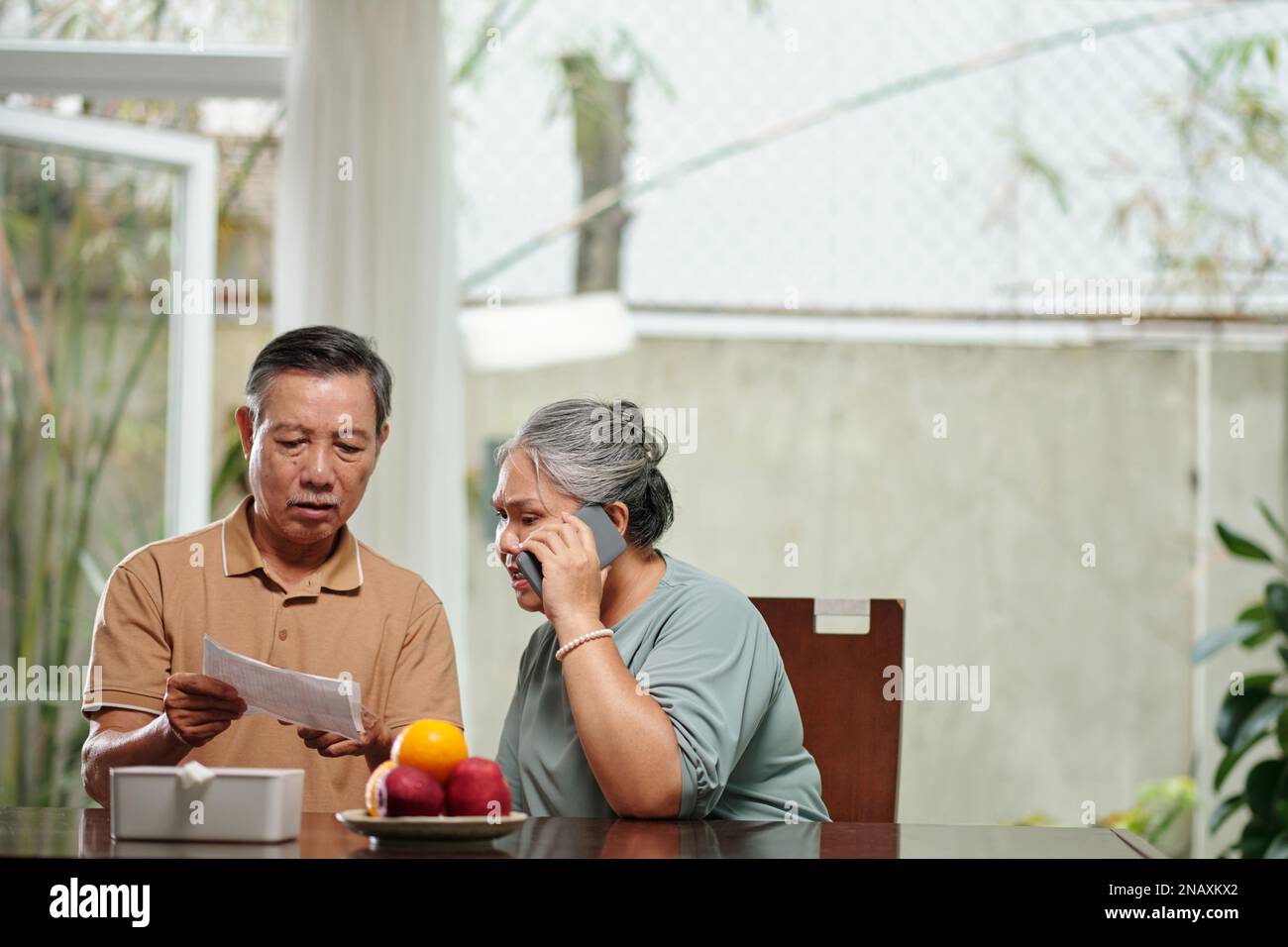 Senior couple calling to utility company to ask questions about figures ...