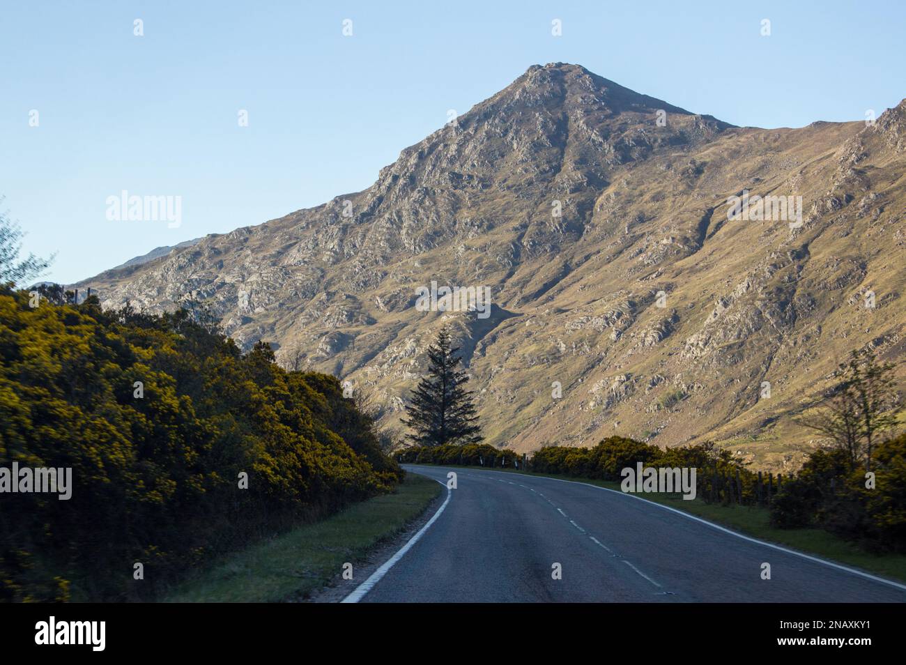 The mountain pass winding between the tall craggy mountains in Glen ...