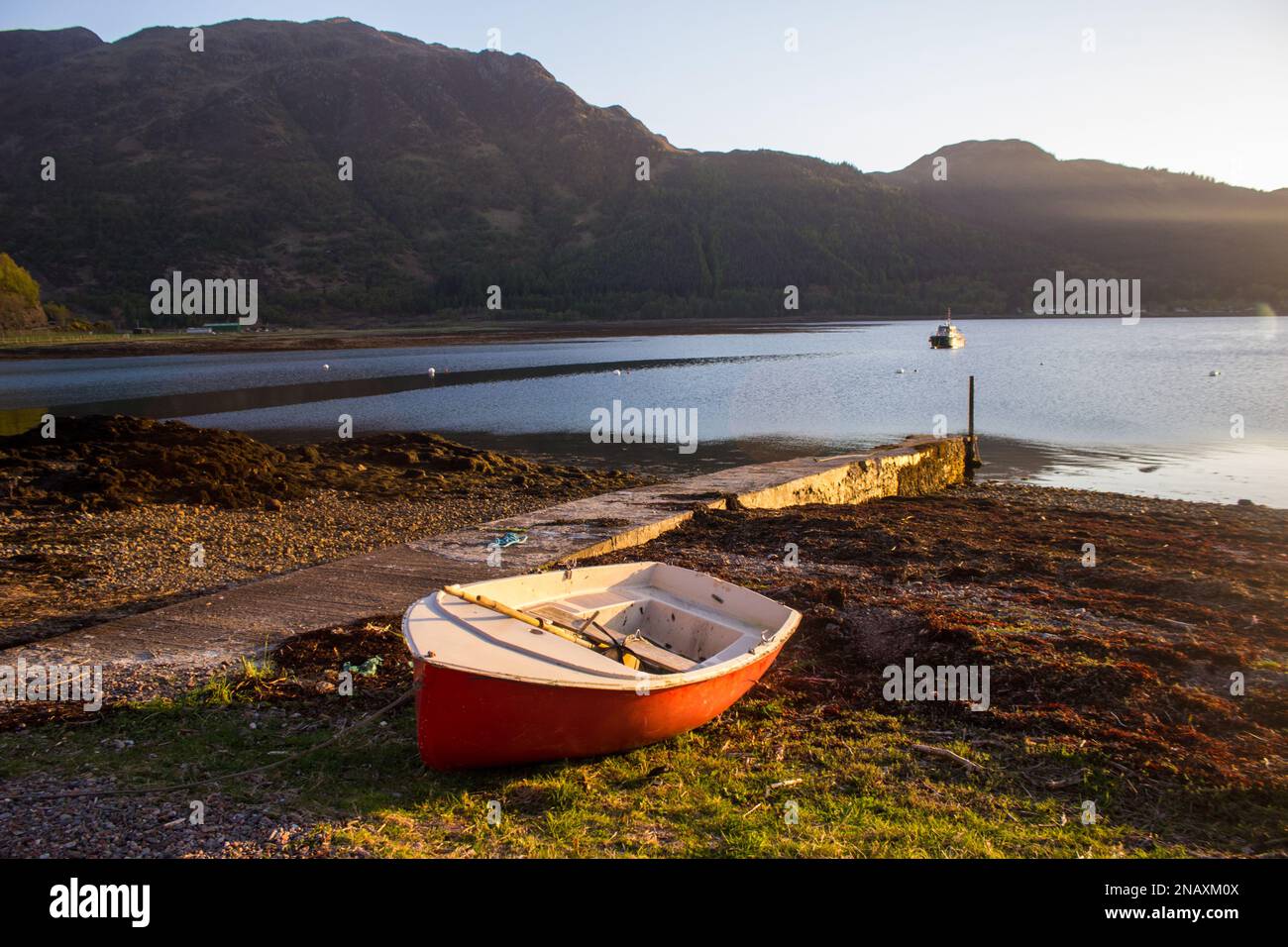 Small red rowboat, beached on the shores of Loch Duich, Scotland, in ...