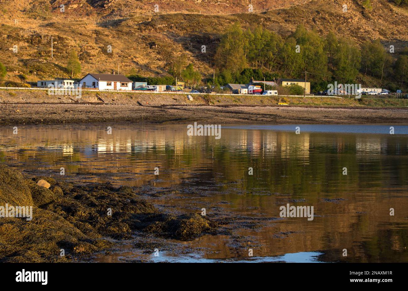 View towards the small village of Invershiel, reflecting in the calm ...