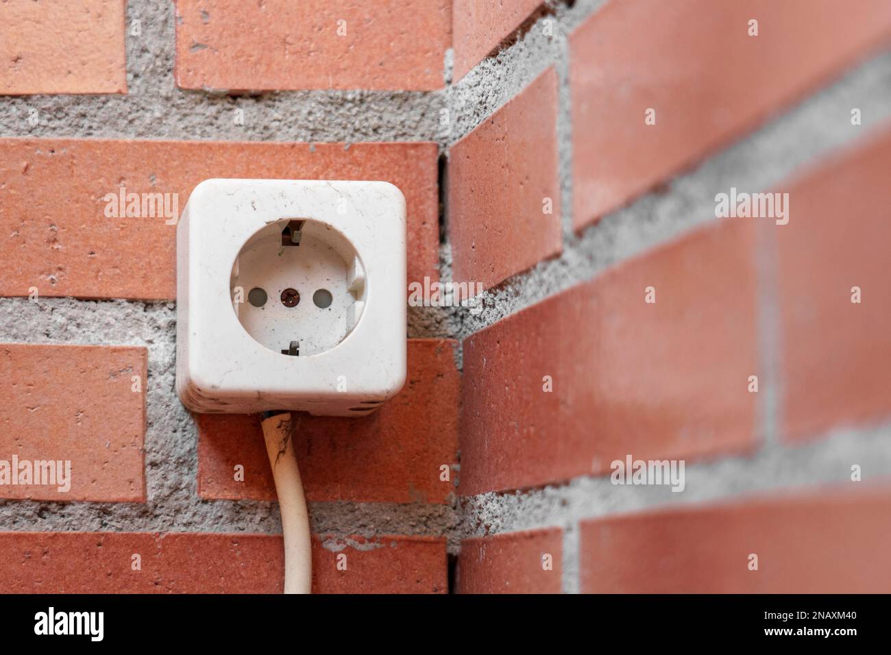 Electric socket outside the garden building on a brick wall. Copy space ...