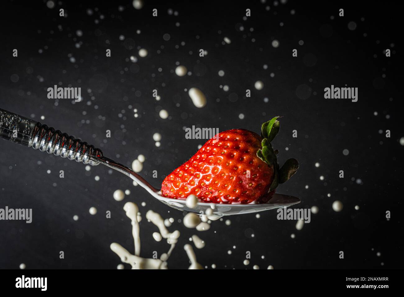 Macro photo of strawberry falling into spoon full of milk Stock Photo ...