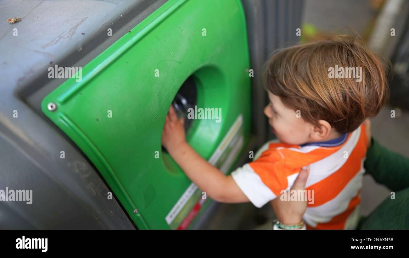 Little boy recycling glass into city recycle dispenser Stock Photo - Alamy