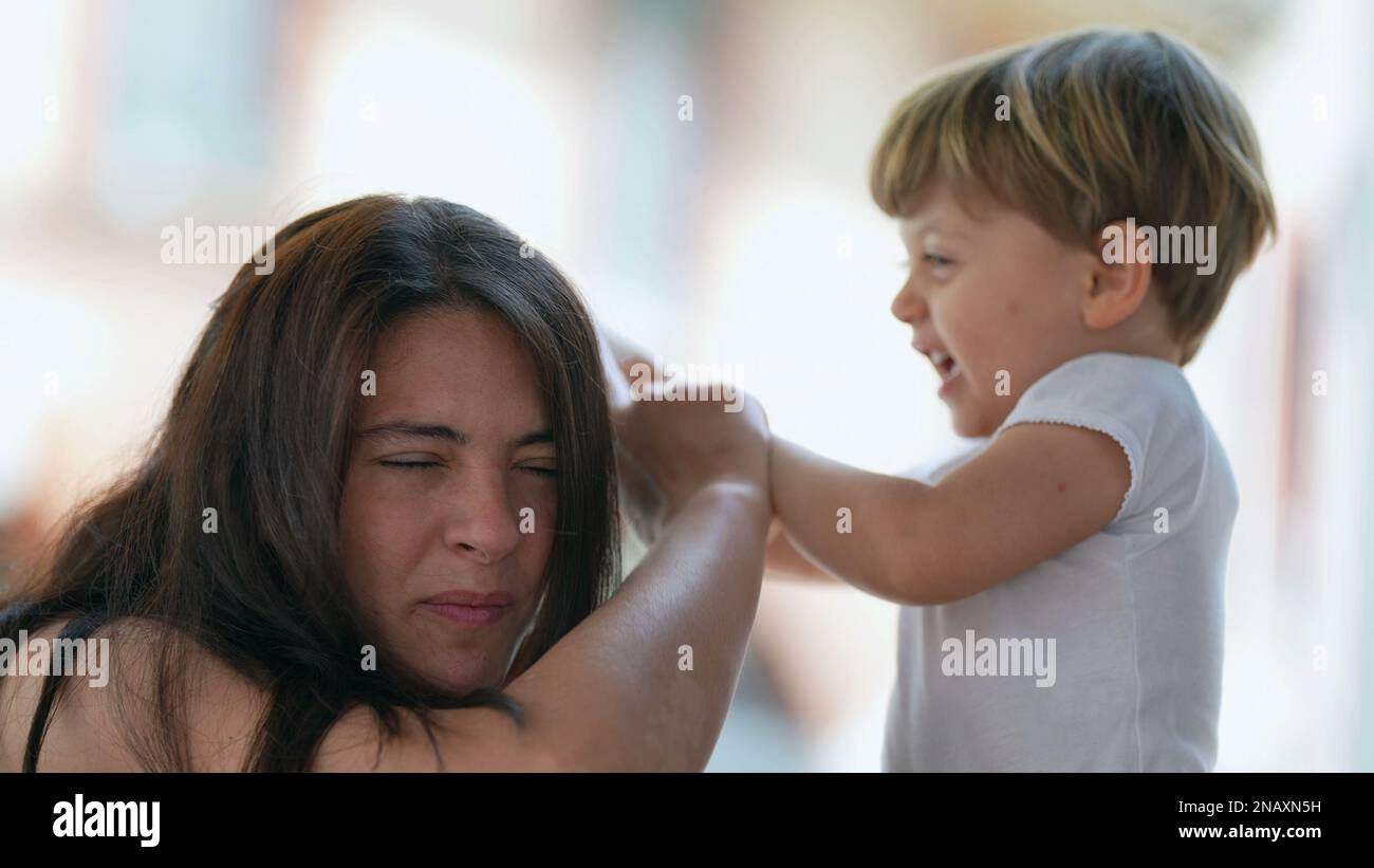 Mischievous child hurting mother. Parenting concept of mom being hit in ...