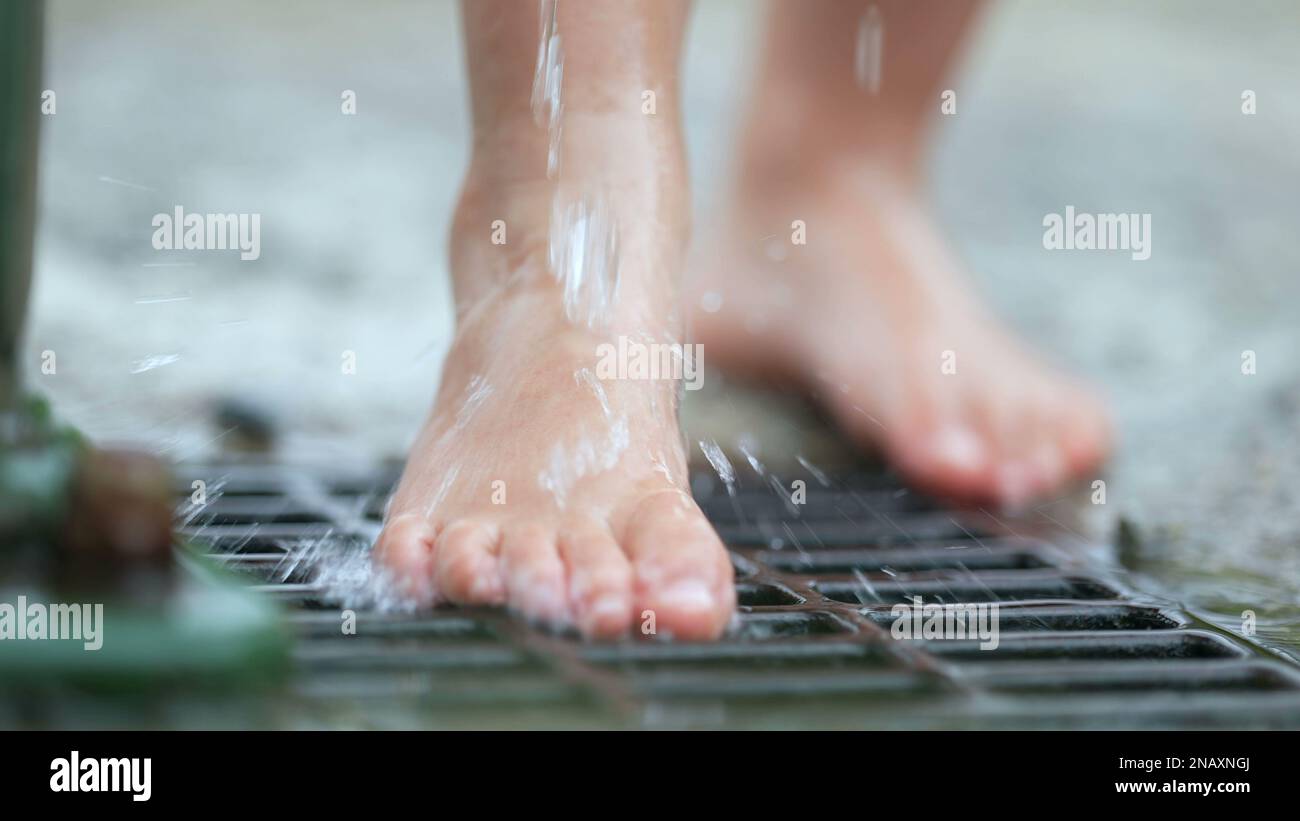 Barefoot Child feet standing by public water faucet pouring liquid in ...