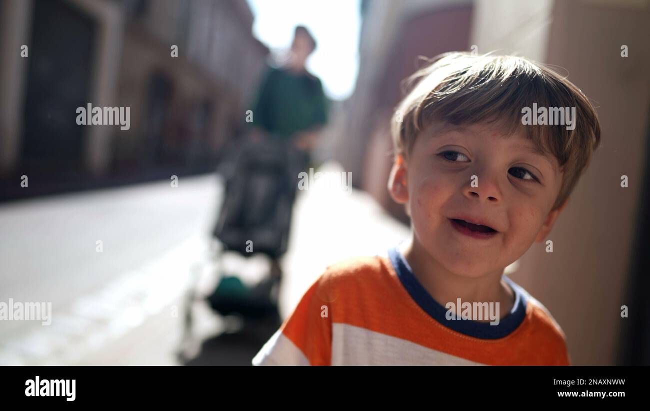 One small boy walking in city sidewalk. Child walks outdoors in urban ...