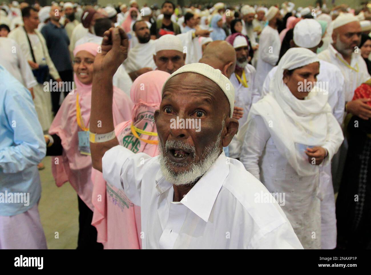 Muslim pilgrims cast stones at a pillar, symbolizing the stoning of ...