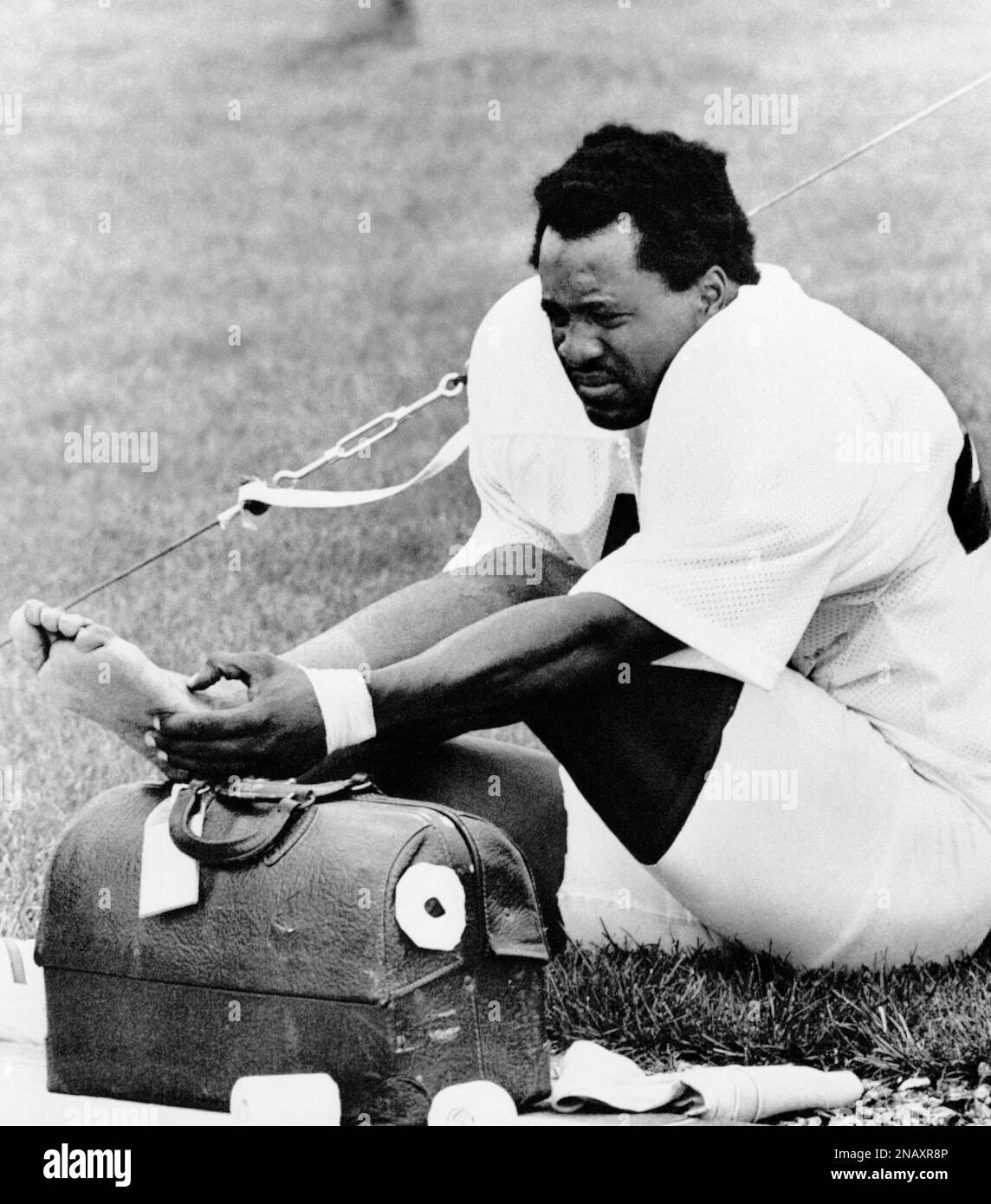 Larry Brown, Washington Redskins running back, checks his ankle resting ...