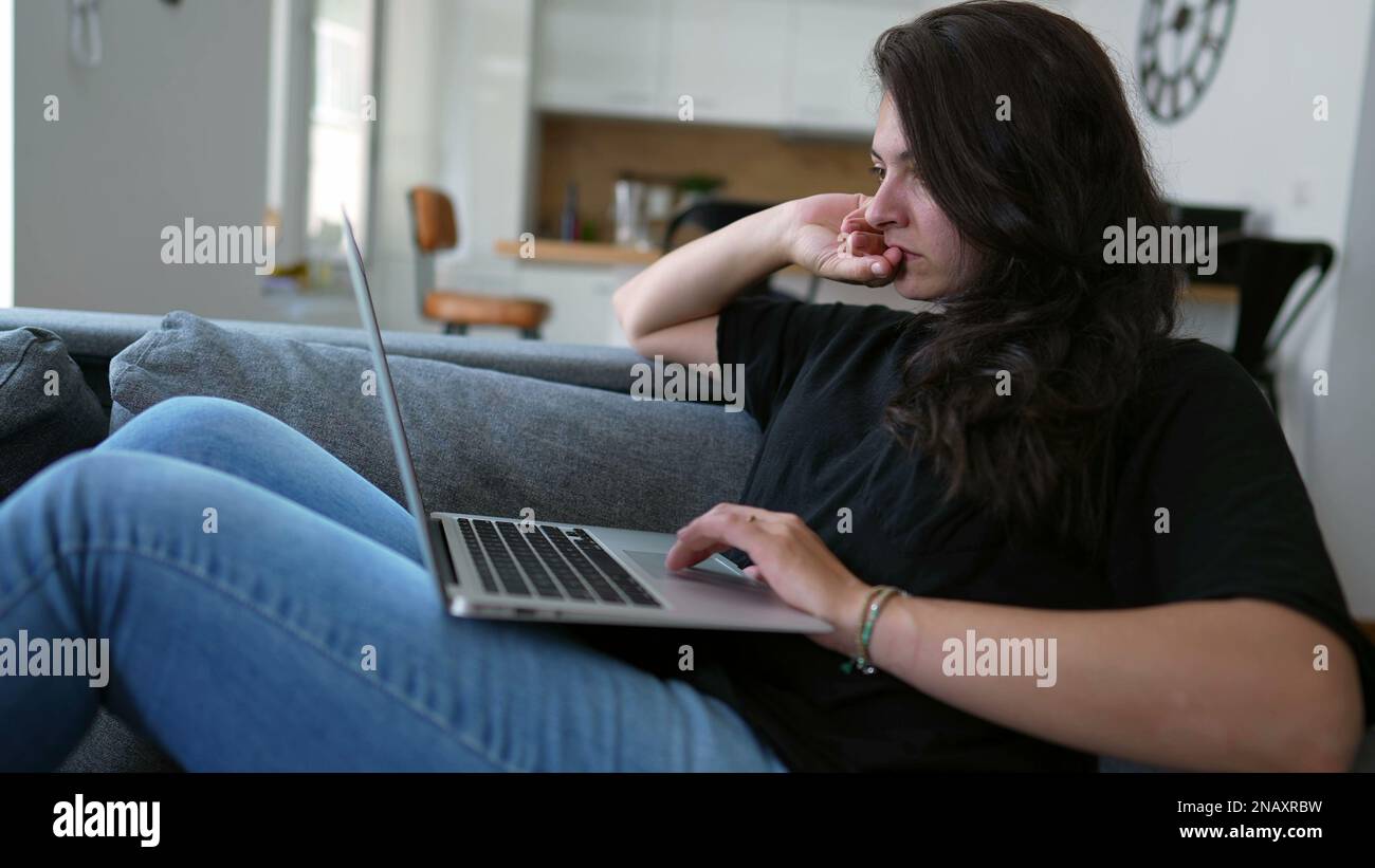 Woman browsing internet at home sitting on couch. Lifestyle modern ...