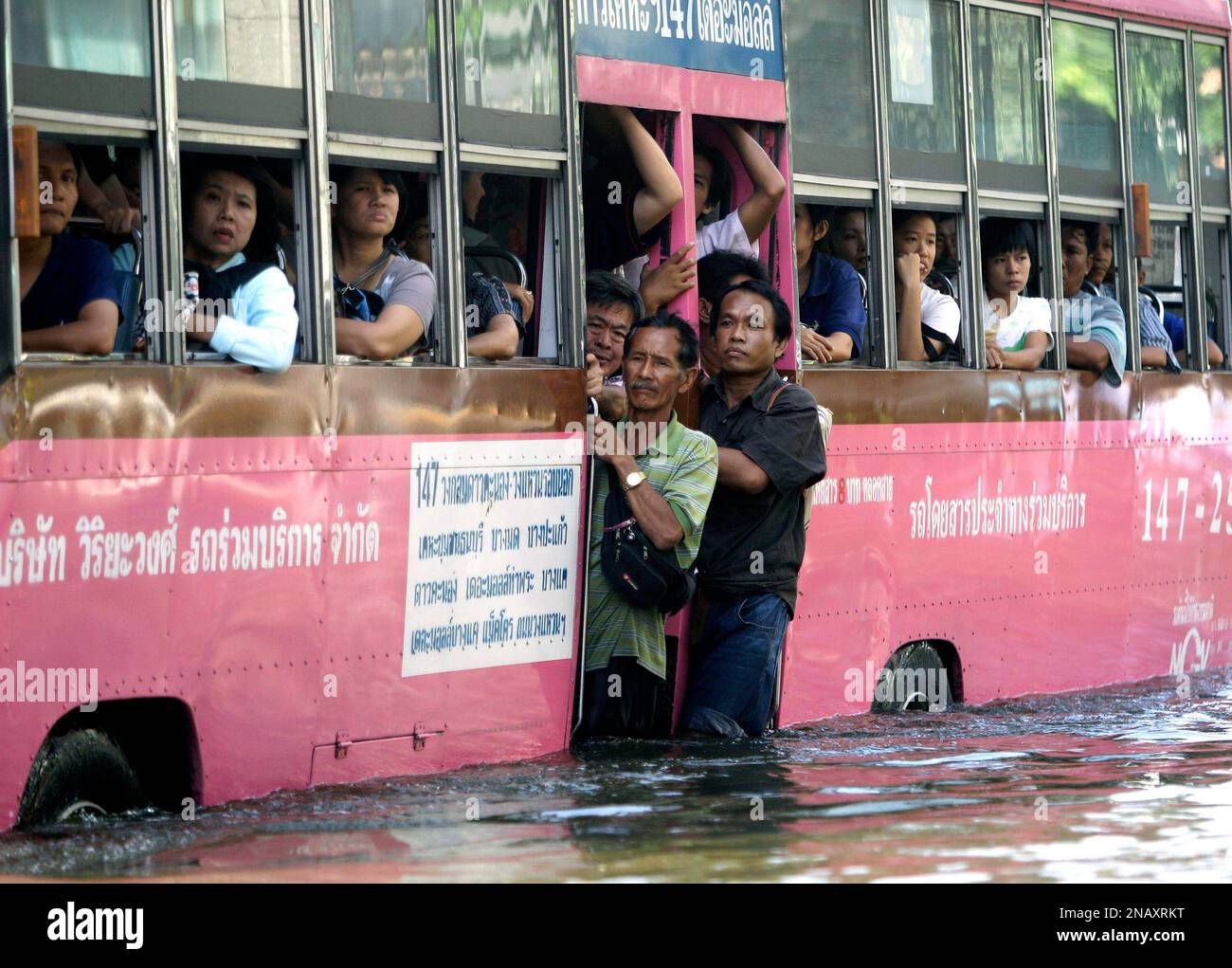 An overloaded bus goes through floodwaters at Bangkok Yai district in ...