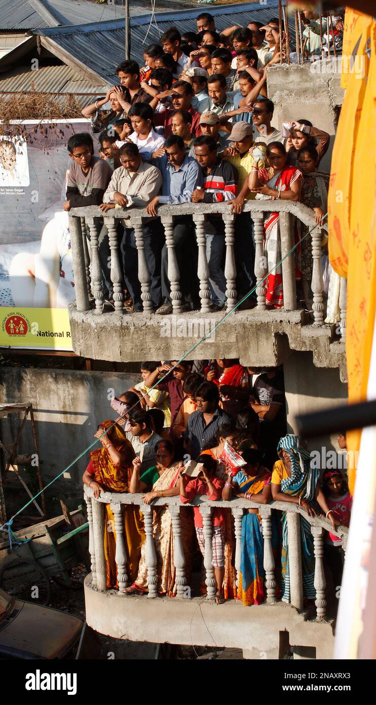 People watch from an under-construction foot bridge as the body of ...