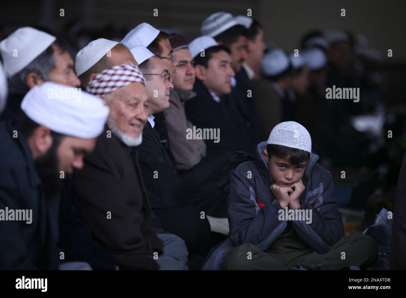 Iranian Sunni Muslims sit prior to performing their Eid al-Adha prayer ...