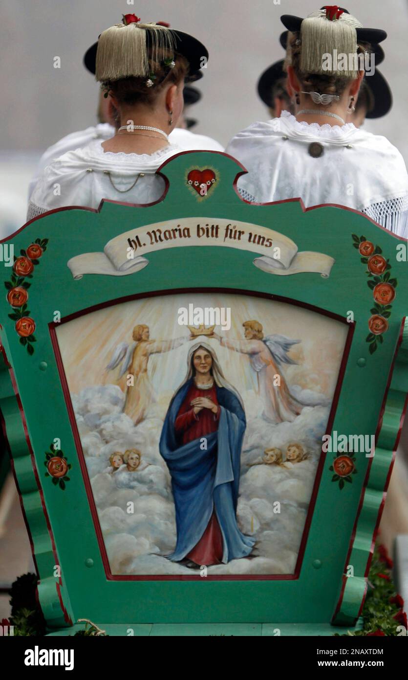 Women wearing the traditional costumes of the region sit in a horse ...