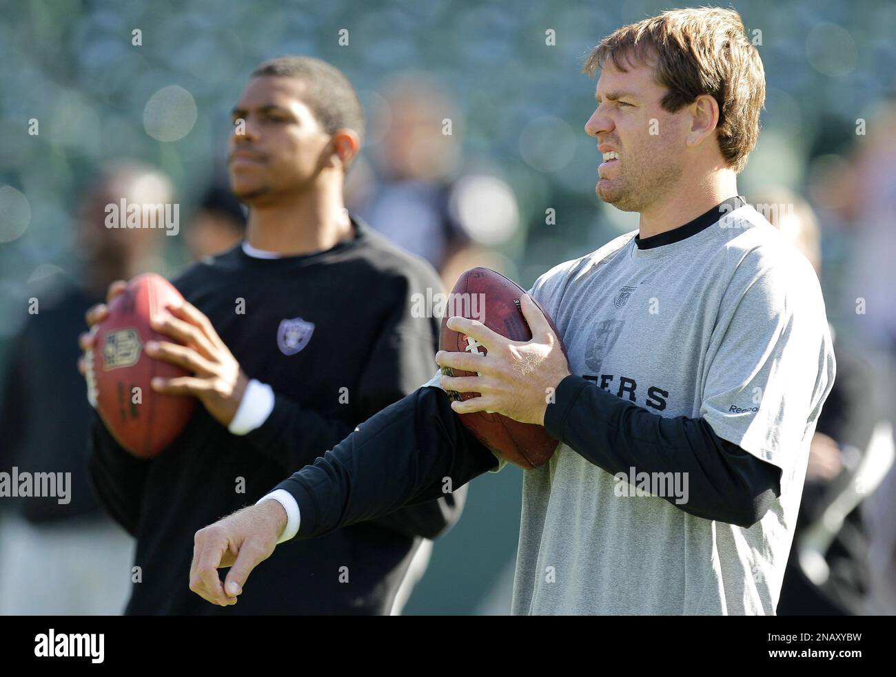 Oakland Raiders quarterback Carson Palmer, right, warms up next to ...