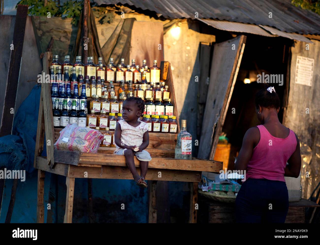 A vendor waits for customers while her daughter sits on the vending ...