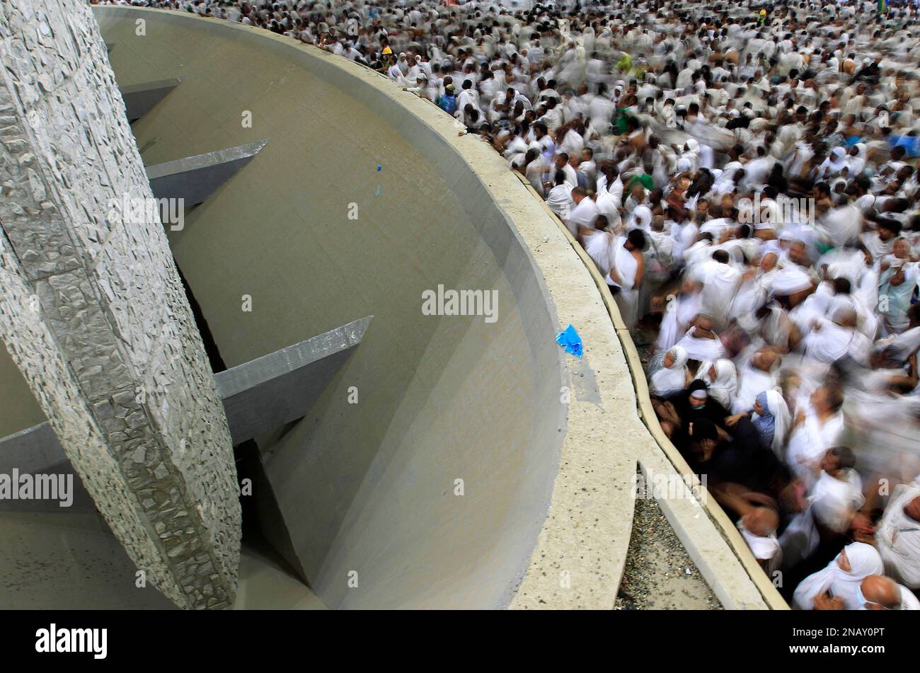Muslim pilgrims cast stones at a pillar, symbolizing the stoning of ...