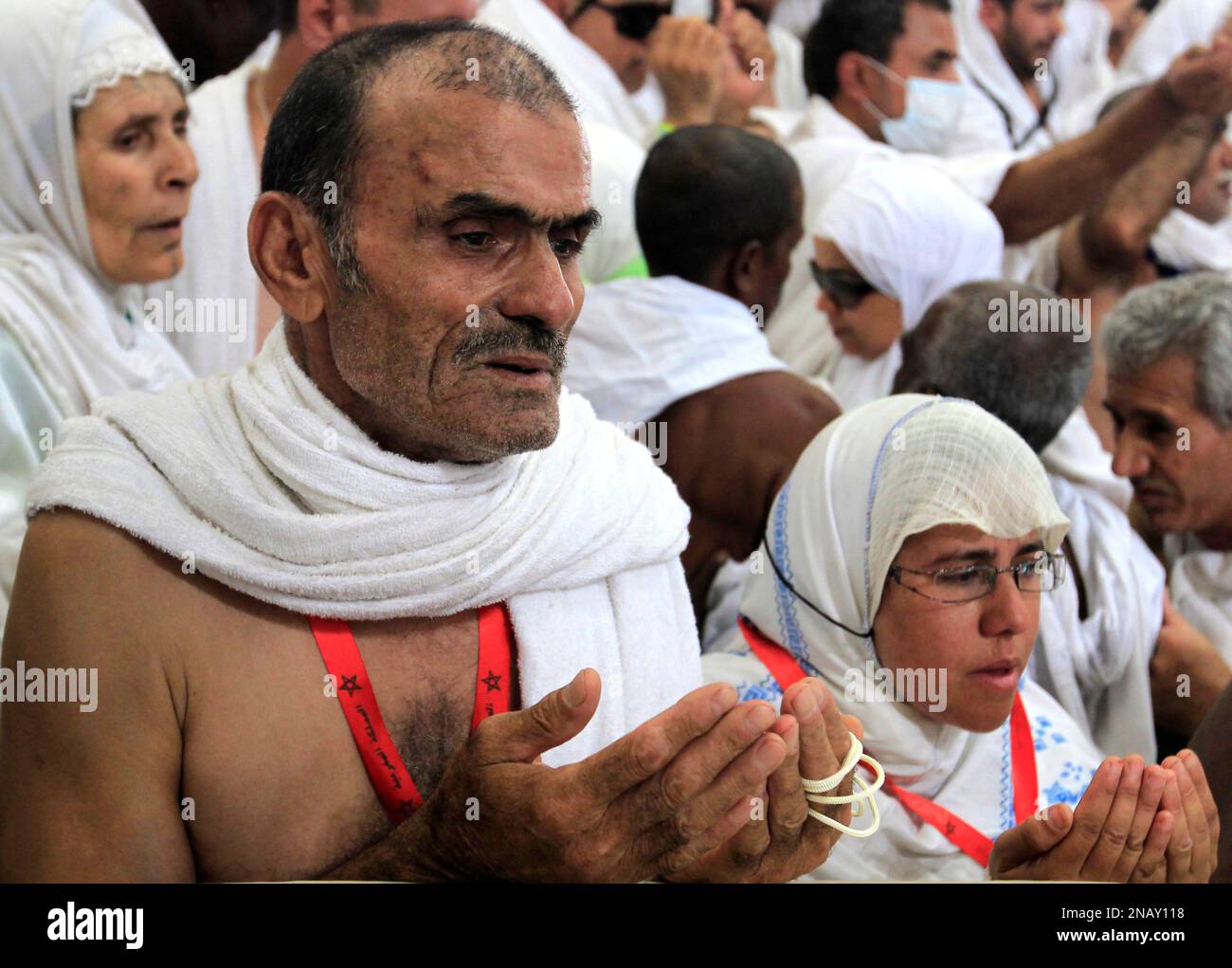 Muslim pilgrims pray after casting stones at a pillar, symbolizing the ...