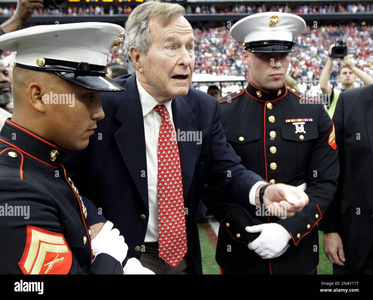 Former President George H. Bush stands between two Marines as he flips ...