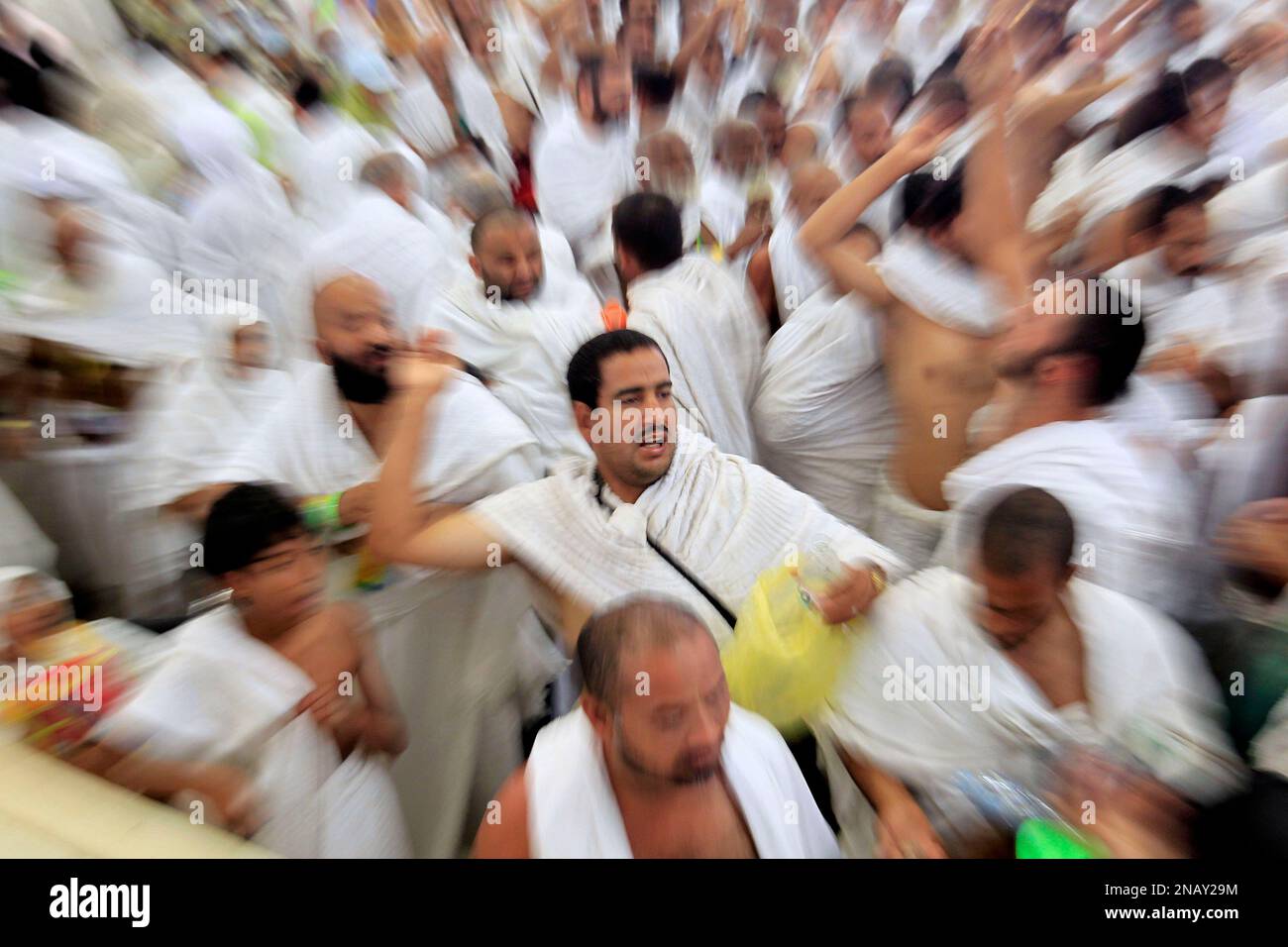 Muslim pilgrims cast stones at a pillar, symbolizing the stoning of ...