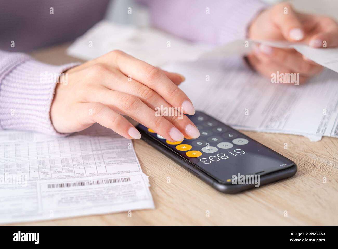 economical woman work on phone calculator at home pay bills taxes on ...