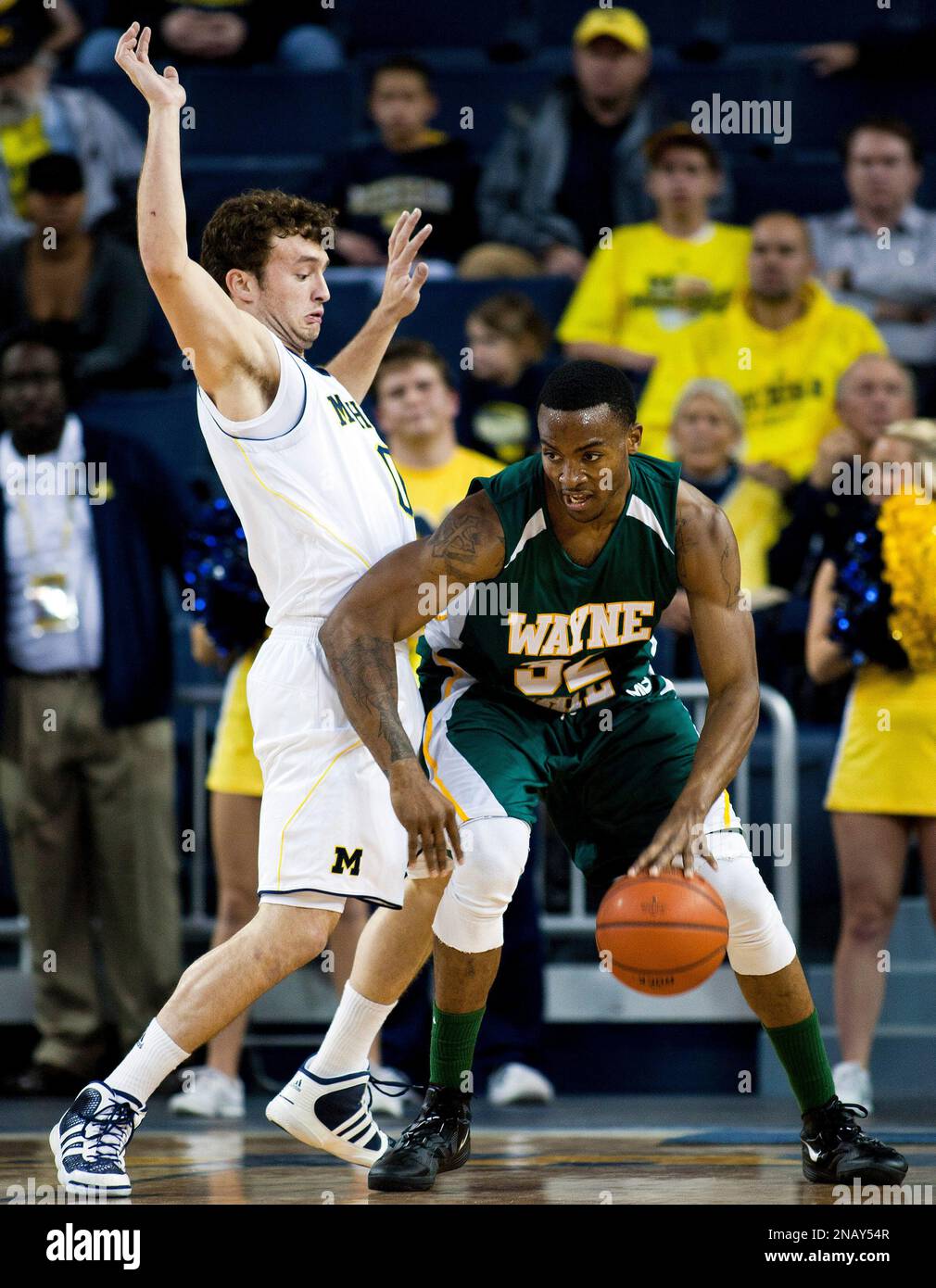 Michigan guard Zack Novak, left, defends Wayne State center Ike Udanoh ...