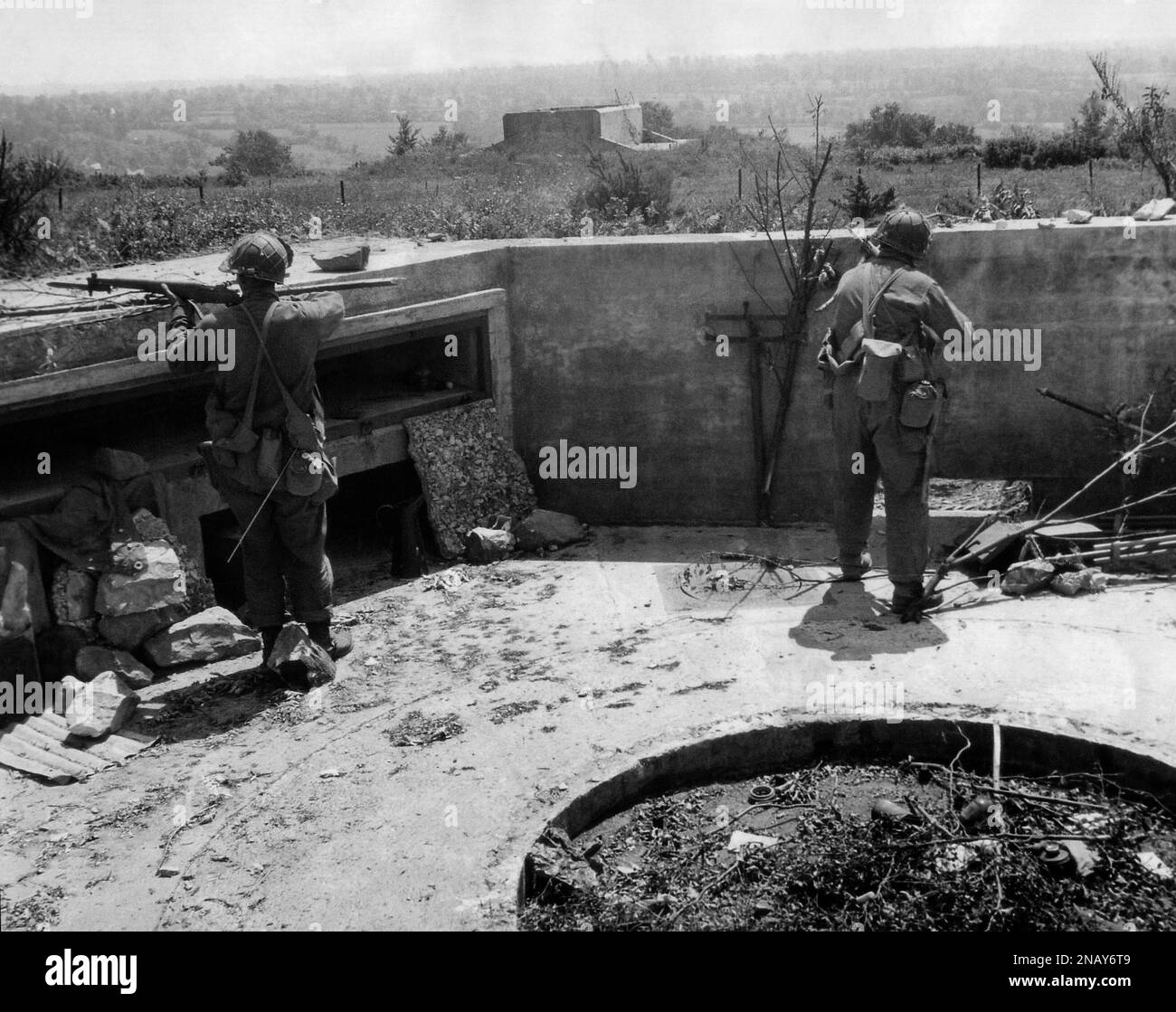 An American patrol turn a captured German defense post to their own use ...