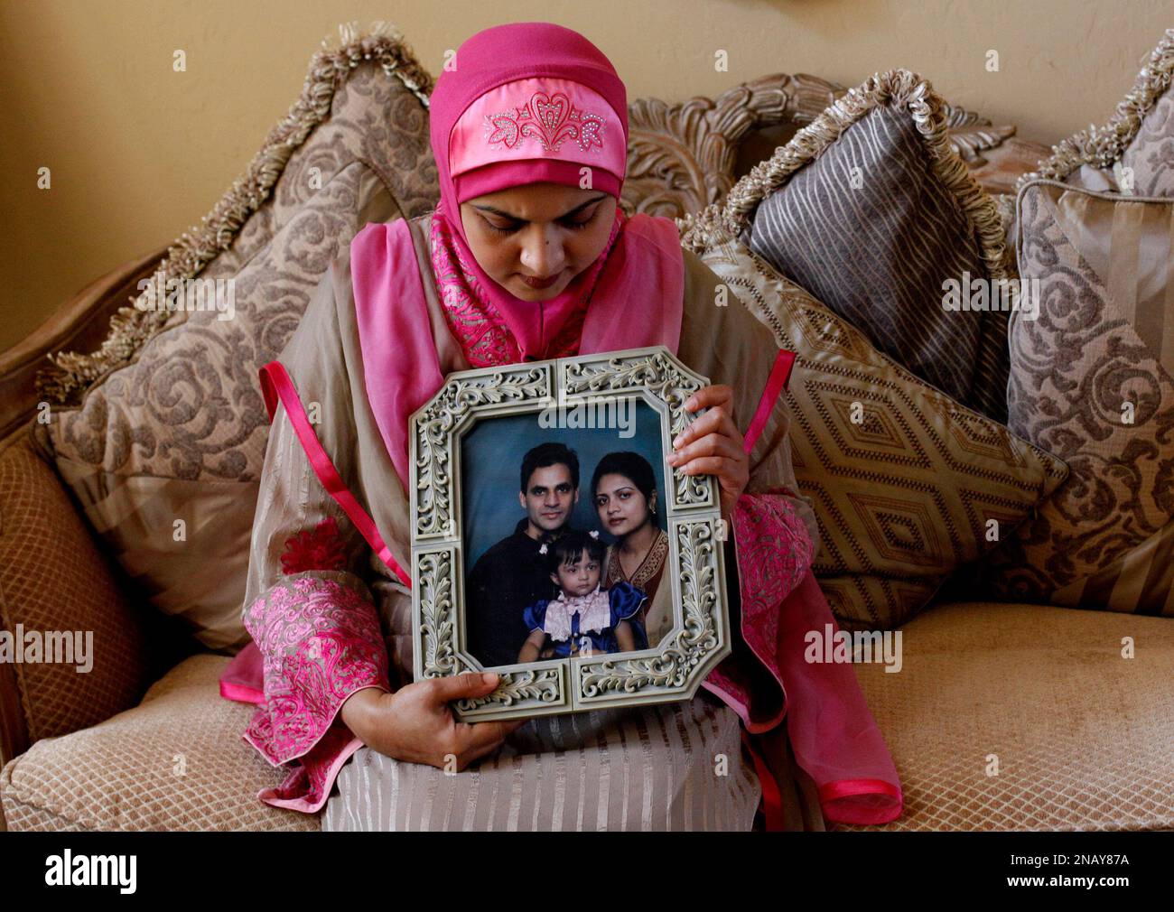 Baraheen Ashrafi poses for a portrait with a family photo of her husband Mohammed Salahuddin ...